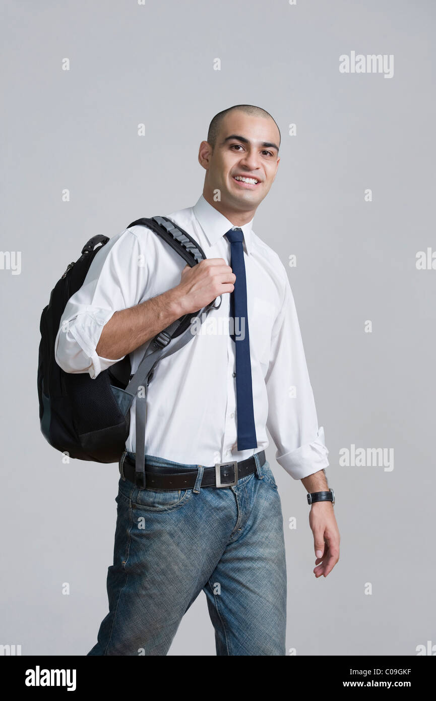 Businessman carrying a backpack and smiling Stock Photo - Alamy