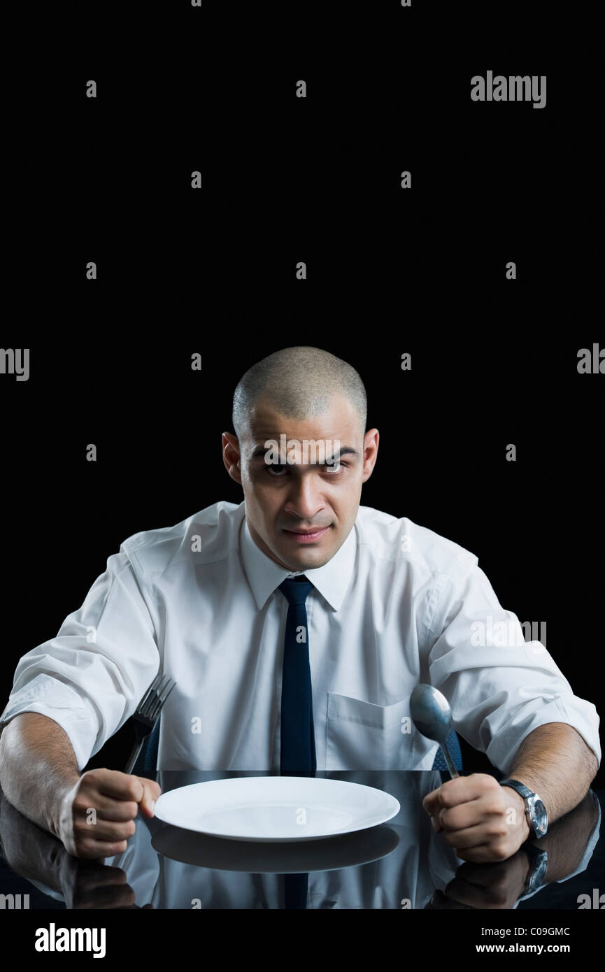 Businessman sitting at a dining table Stock Photo - Alamy
