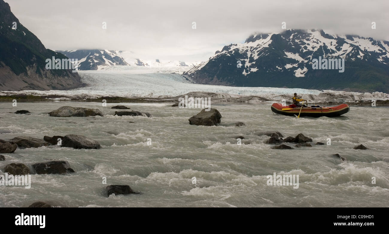 A white water raft guide steers his raft through a short set of rapids ...