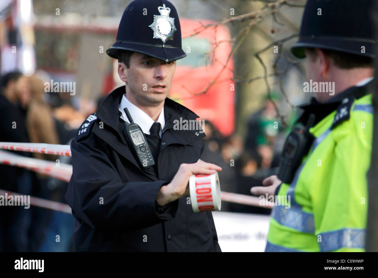 Police officer putting out cordon tape at demo in London Stock Photo ...
