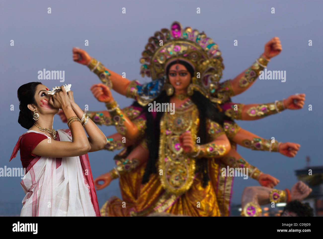 Woman blowing conch shell at Durga puja Stock Photo - Alamy