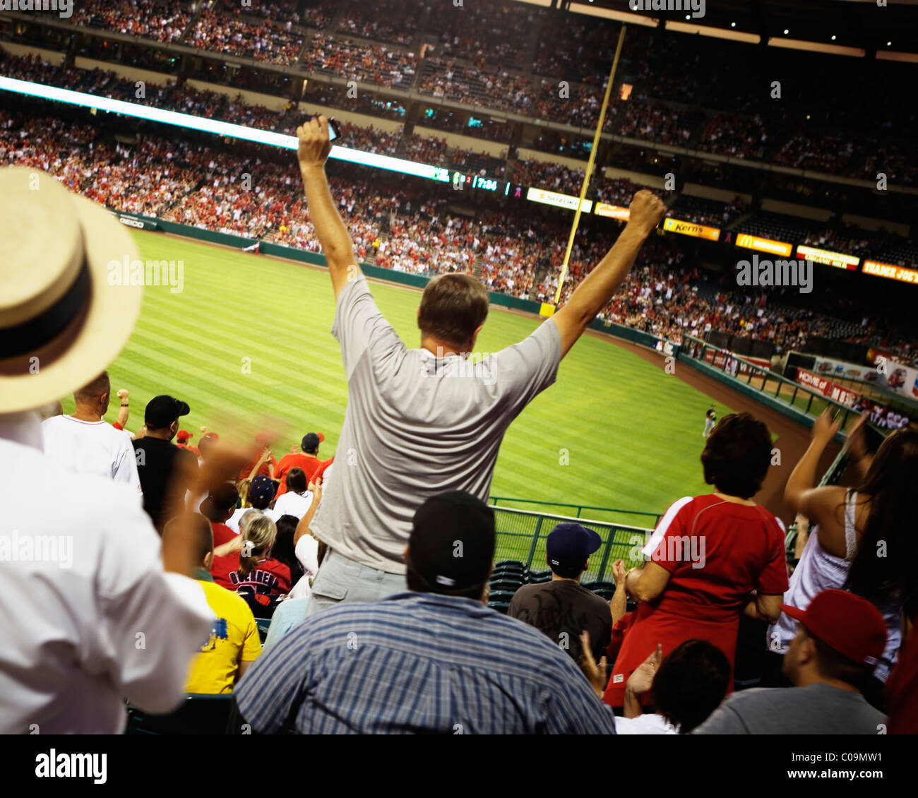Rear view of a baseball fan raising his arms during a game at the Angel ...