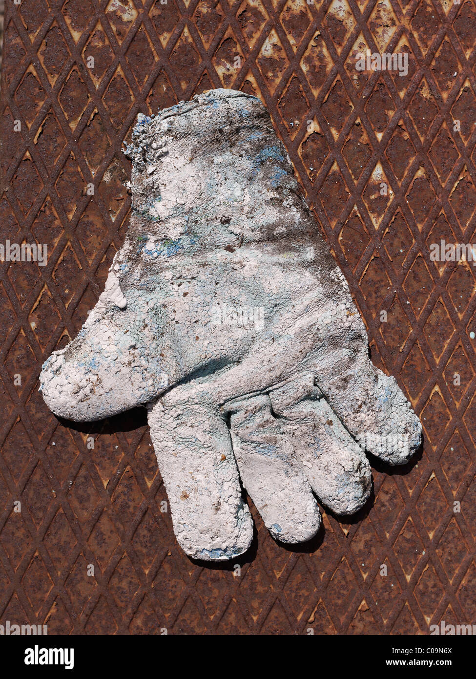 Badly worn work glove on rusty metal plate Stock Photo - Alamy