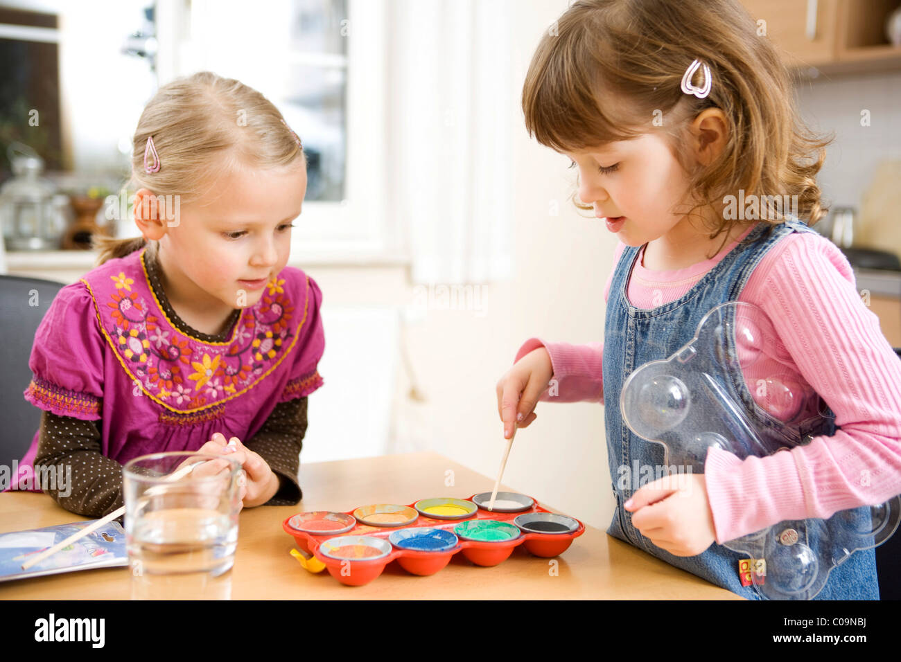 Two girls painting with water colours Stock Photo - Alamy