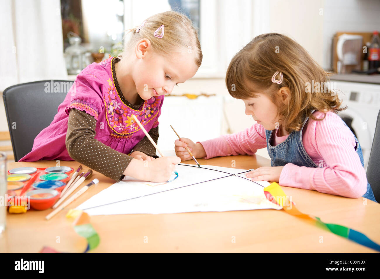 Two girls painting with water colours Stock Photo - Alamy