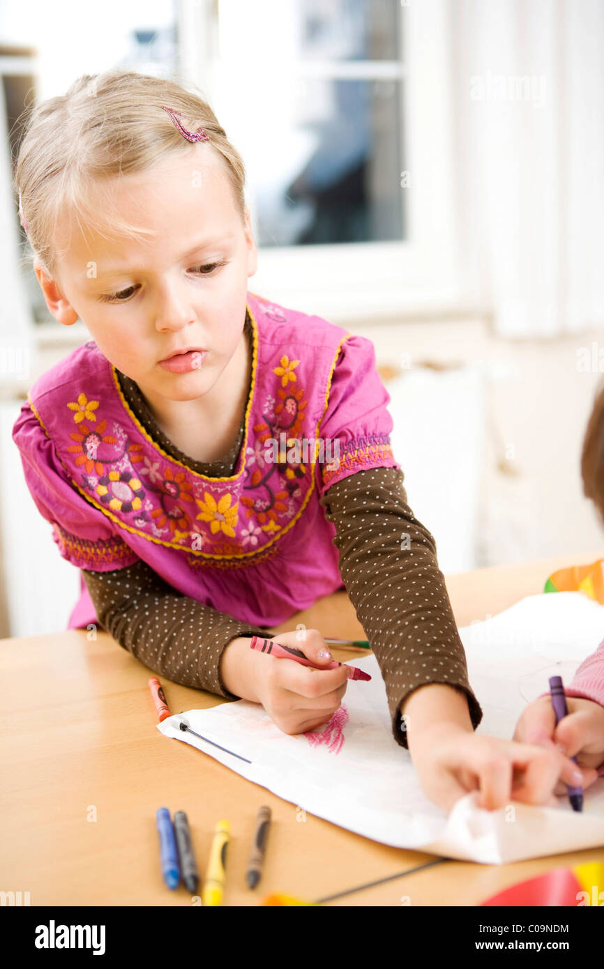 A girl drawing with wax crayons Stock Photo - Alamy