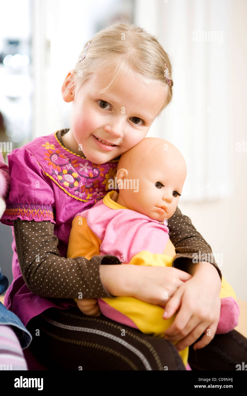 A girl hugging her doll Stock Photo - Alamy