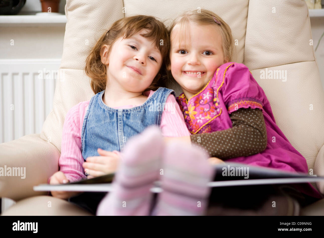 Two girls reading a book Stock Photo - Alamy