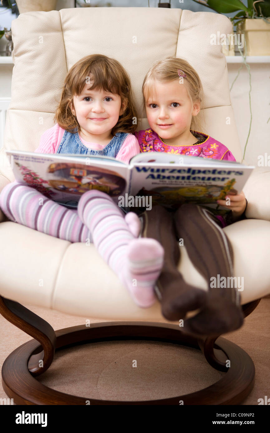 Two girls reading a book Stock Photo - Alamy