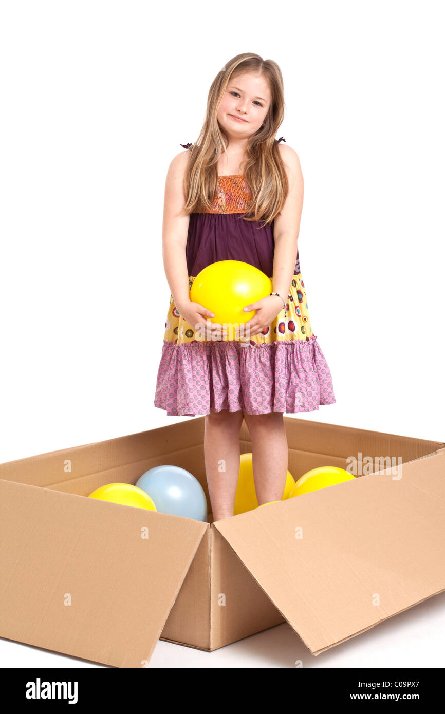 Girl standing in a large cardboard box with colorful balloons Stock ...