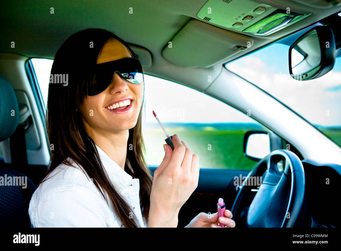 Young woman putting on makeup in the car Stock Photo - Alamy