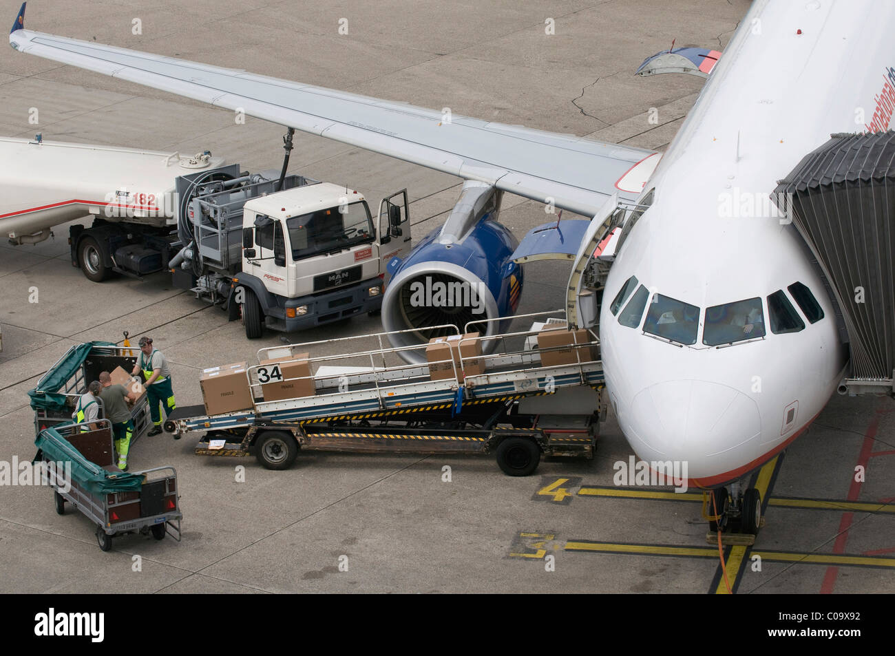 Airplane being refueled and loaded on the manoeuvering area, air cargo ...