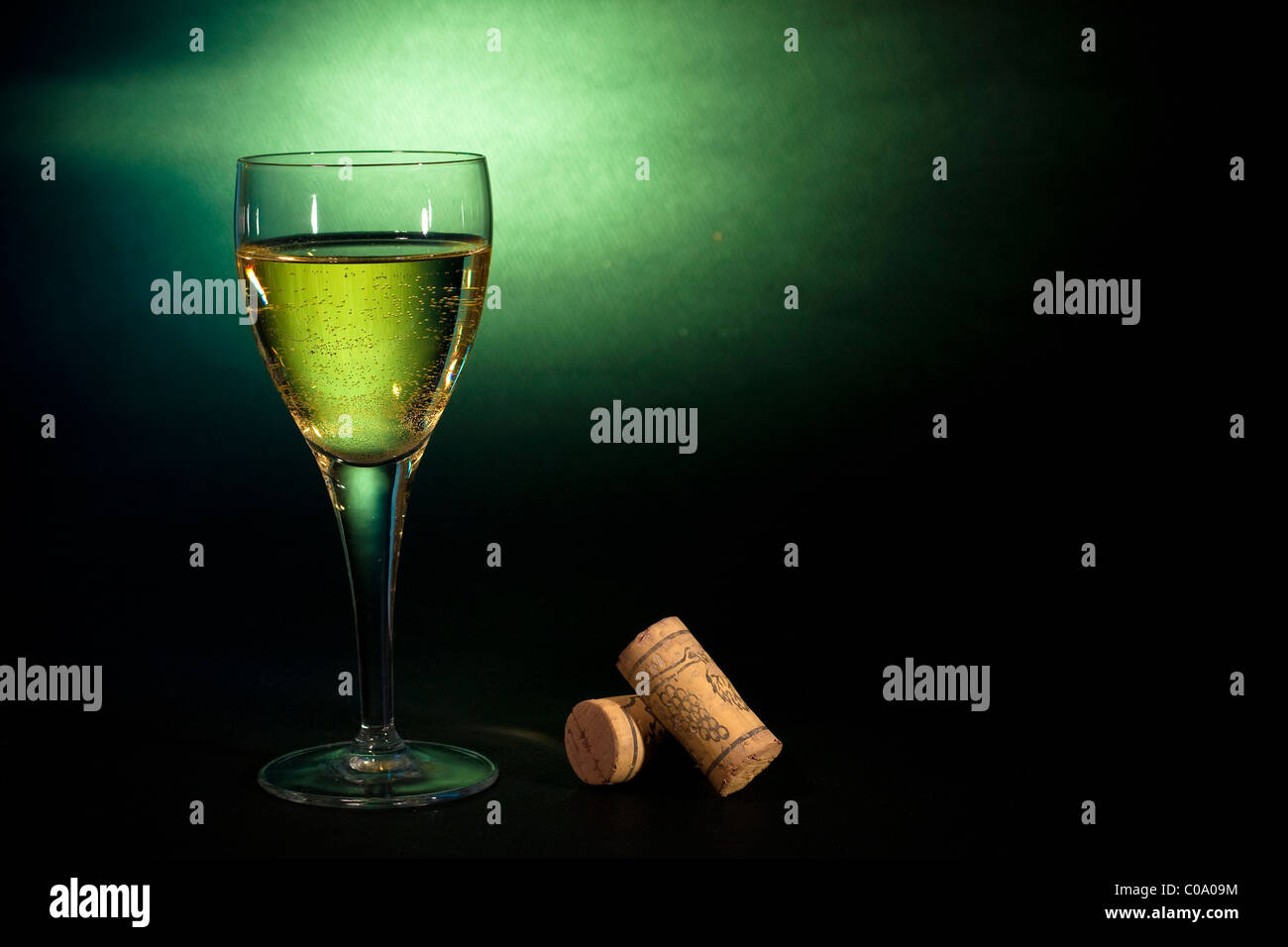 White wine in a glass, on black-green background. Art background Stock ...
