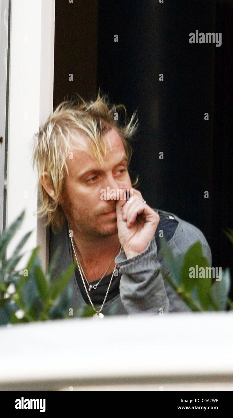 Rhys Ifans appears to have just woken up as he hangs out of the window ...