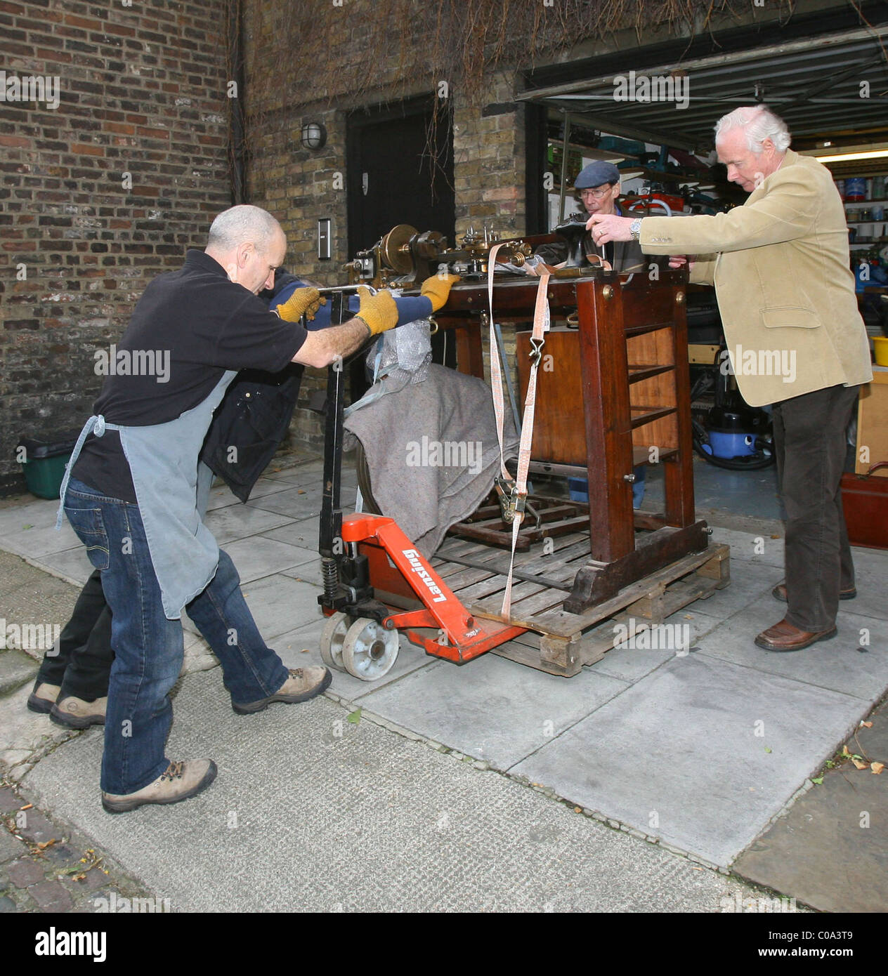 Removal men from the auction house Bonhams removing an antique workman ...