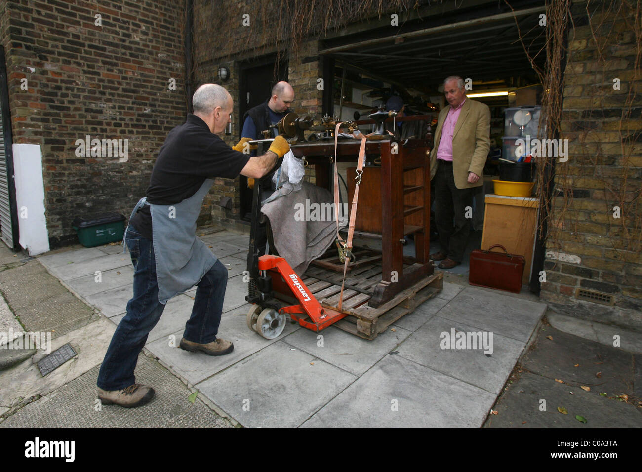 Removal men from the auction house Bonhams removing an antique workman ...