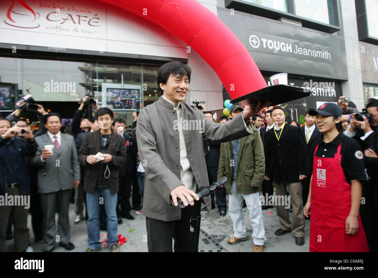 Jackie Chan hands out free coffee to members of the public at the opening of his new coffeeshop ...