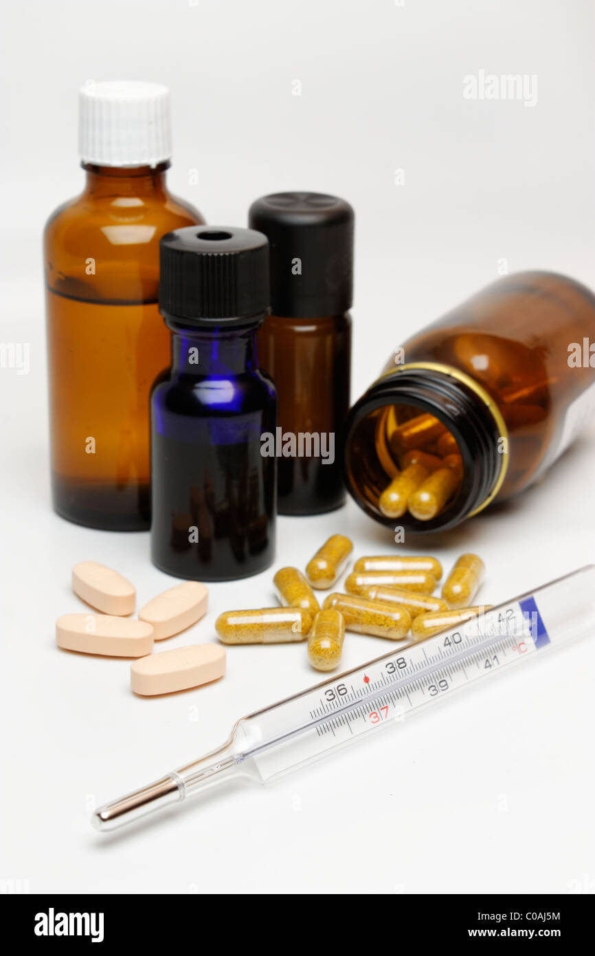 Essential oil bottles, capsules, pills and a thermometer Stock Photo ...