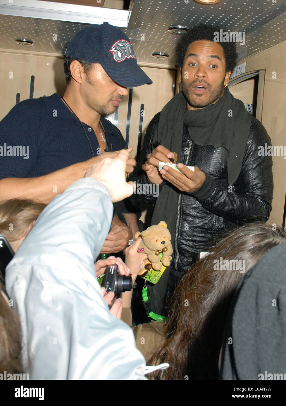 Lenny Kravitz signing autographs for a group of fans gathered outside ...