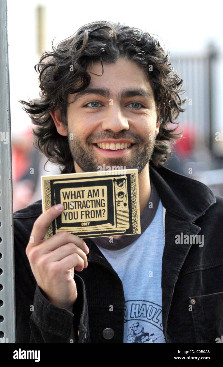 Adrian Grenier, Director holds up a postcard with the words "What am I ...