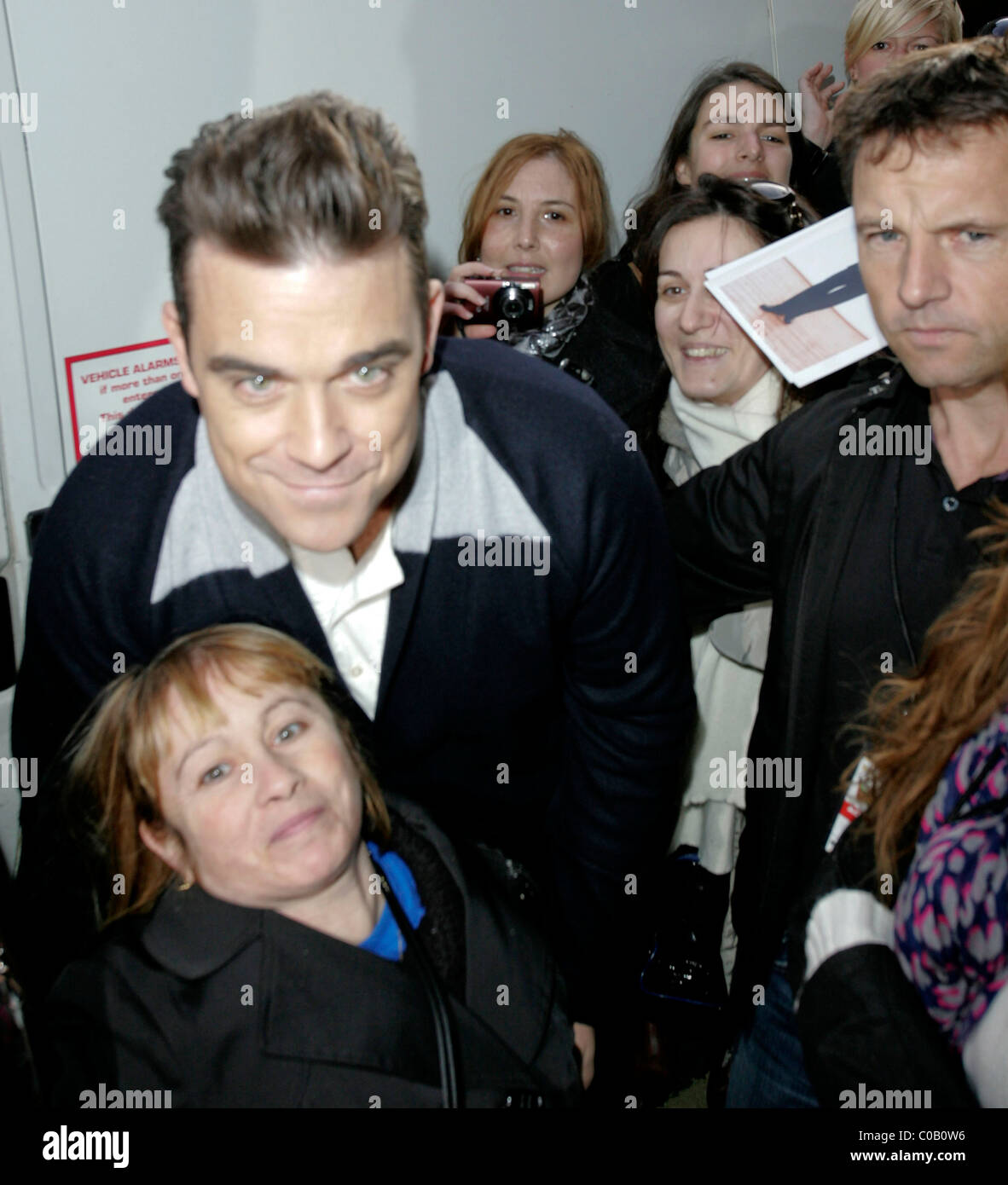 Robbie Williams poses with a fan outside The Royal Albert Hall. London ...