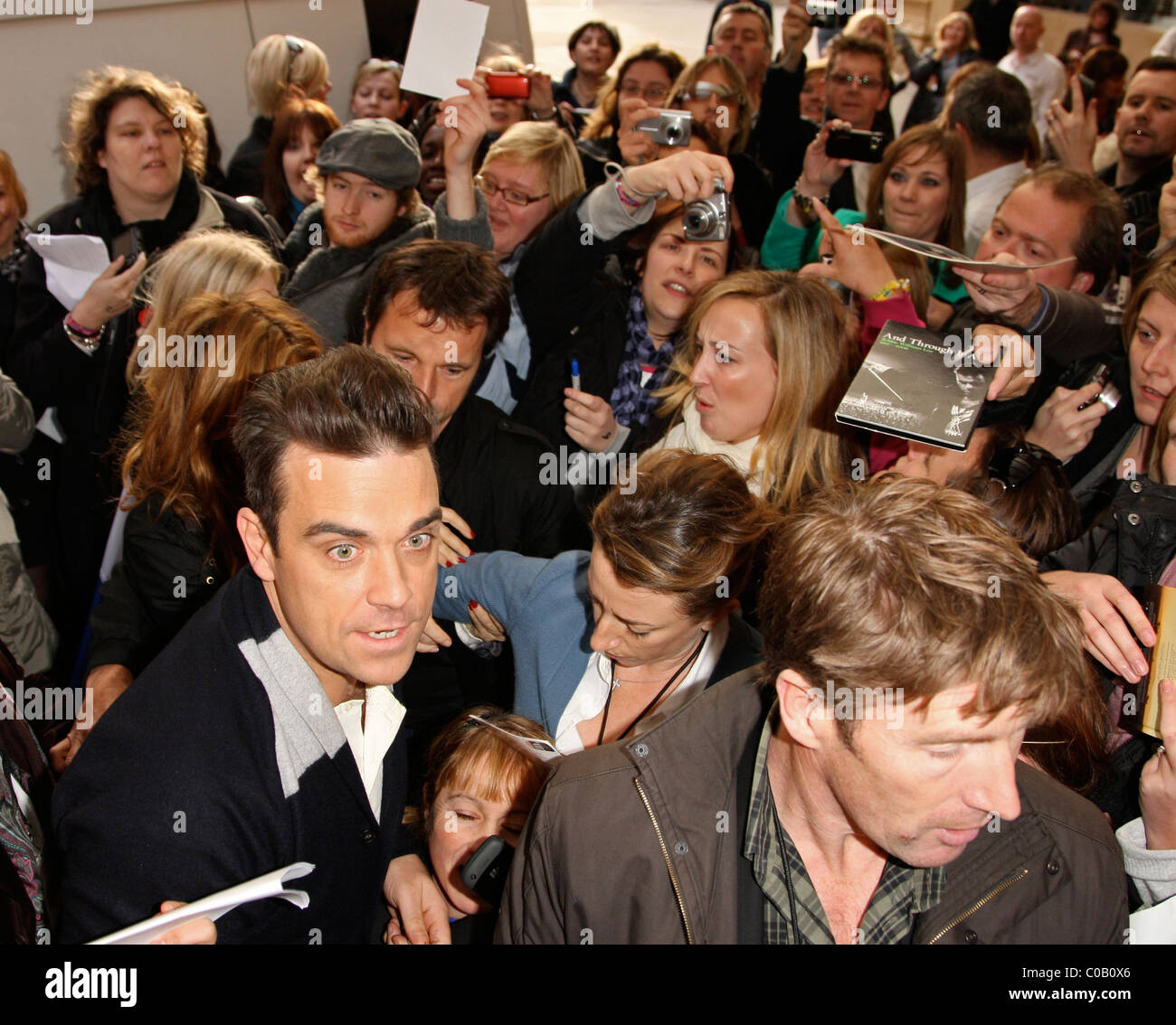 Robbie Williams signs autographs for fans outside The Royal Albert Hall ...