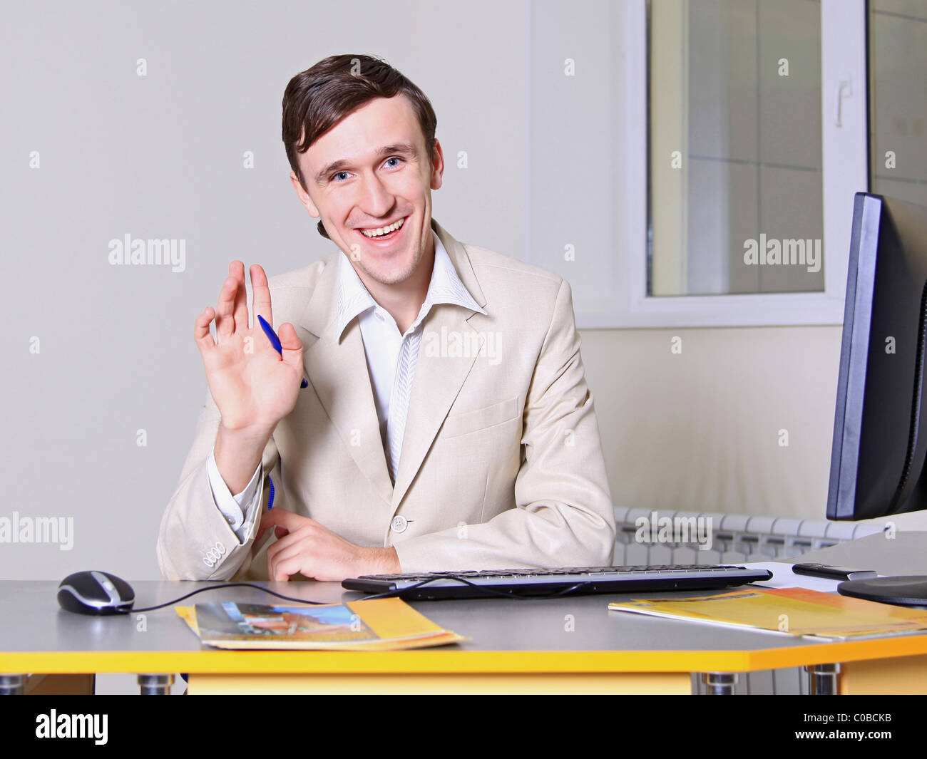 A young man works in an office at a table and a computer Stock Photo ...
