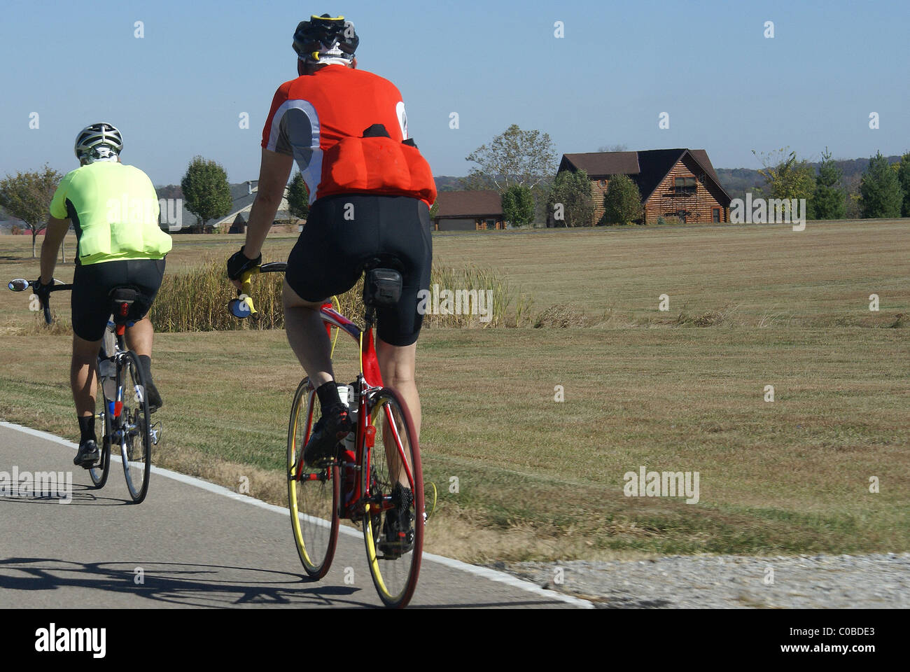Men riding bicycles on country road Stock Photo - Alamy