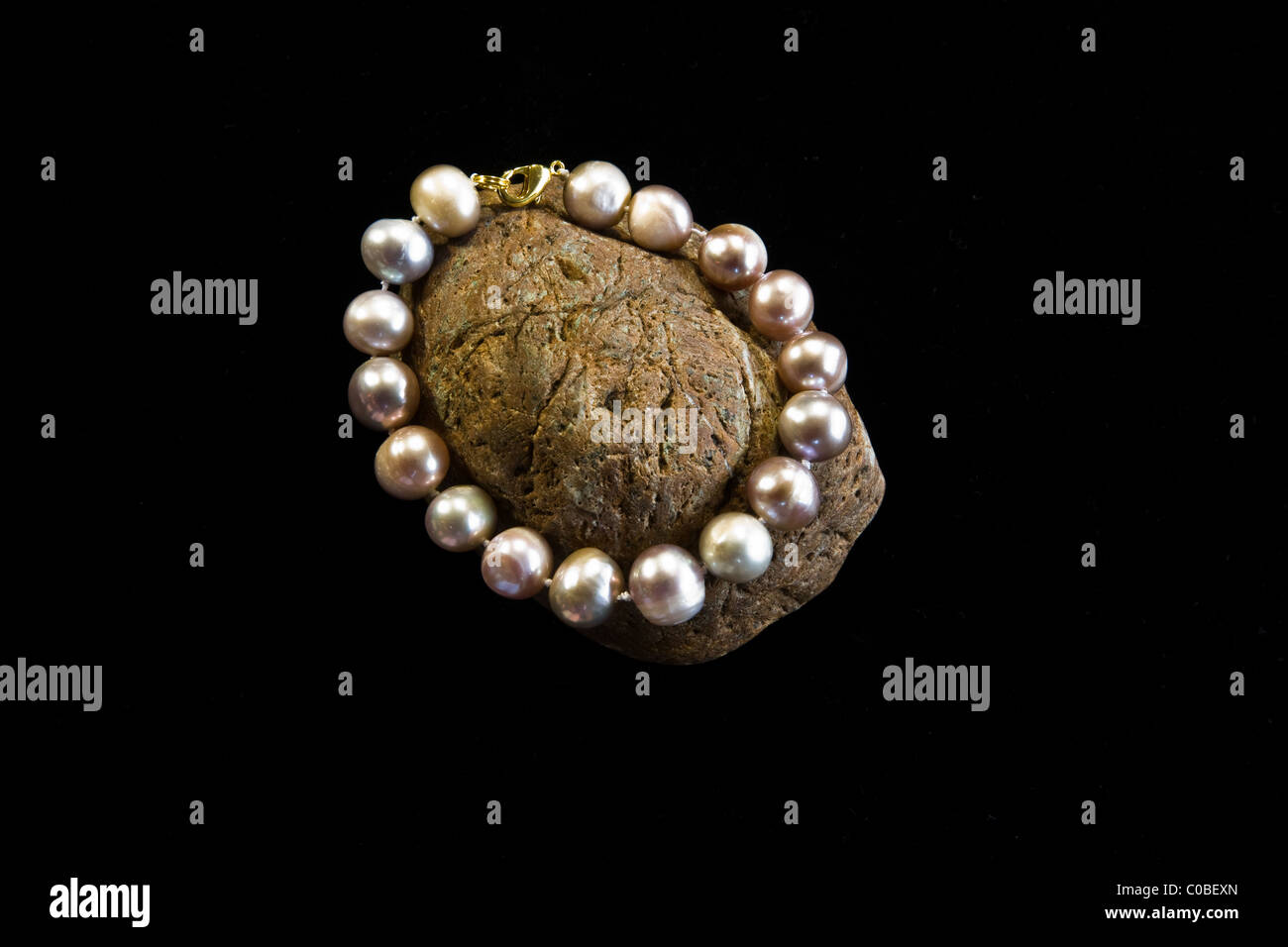 Freshwater pearls displayed on a rock on black velvet - 3 Stock Photo ...