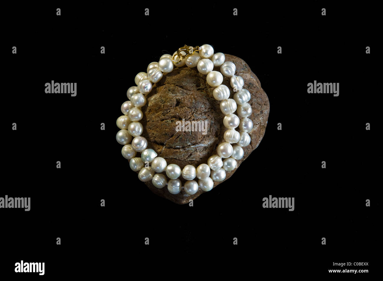 Freshwater pearls displayed on a rock on black velvet - 2 Stock Photo ...