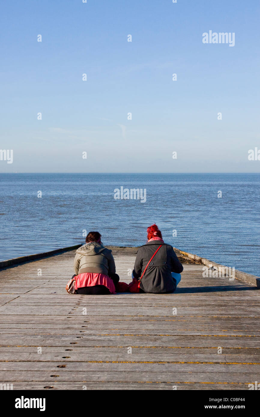 Two girls passing the time of day at Whitstable Stock Photo - Alamy