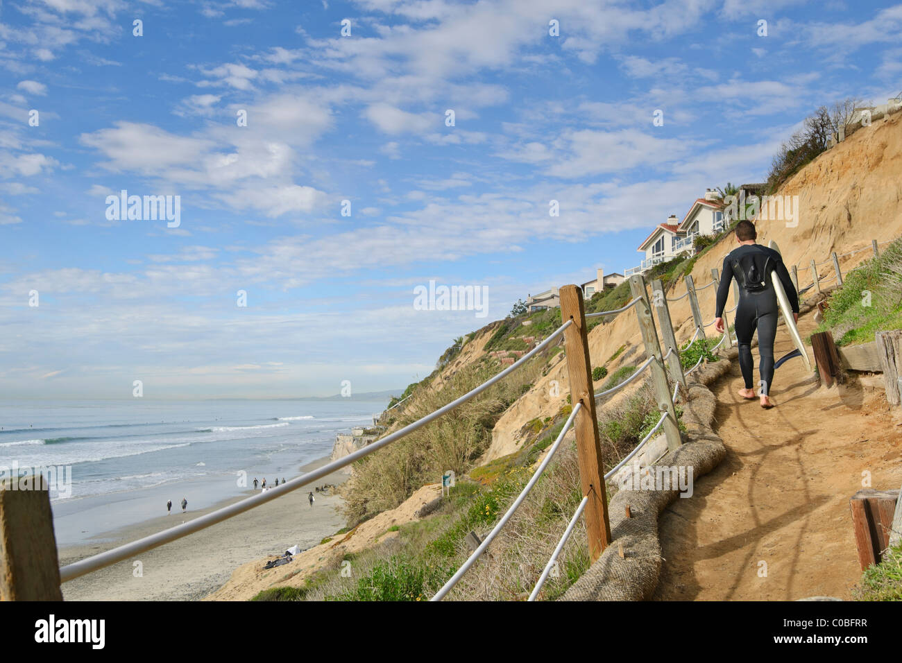 Surfers climbing a coastal bluff trail at Beacons Beach in Encinitas ...
