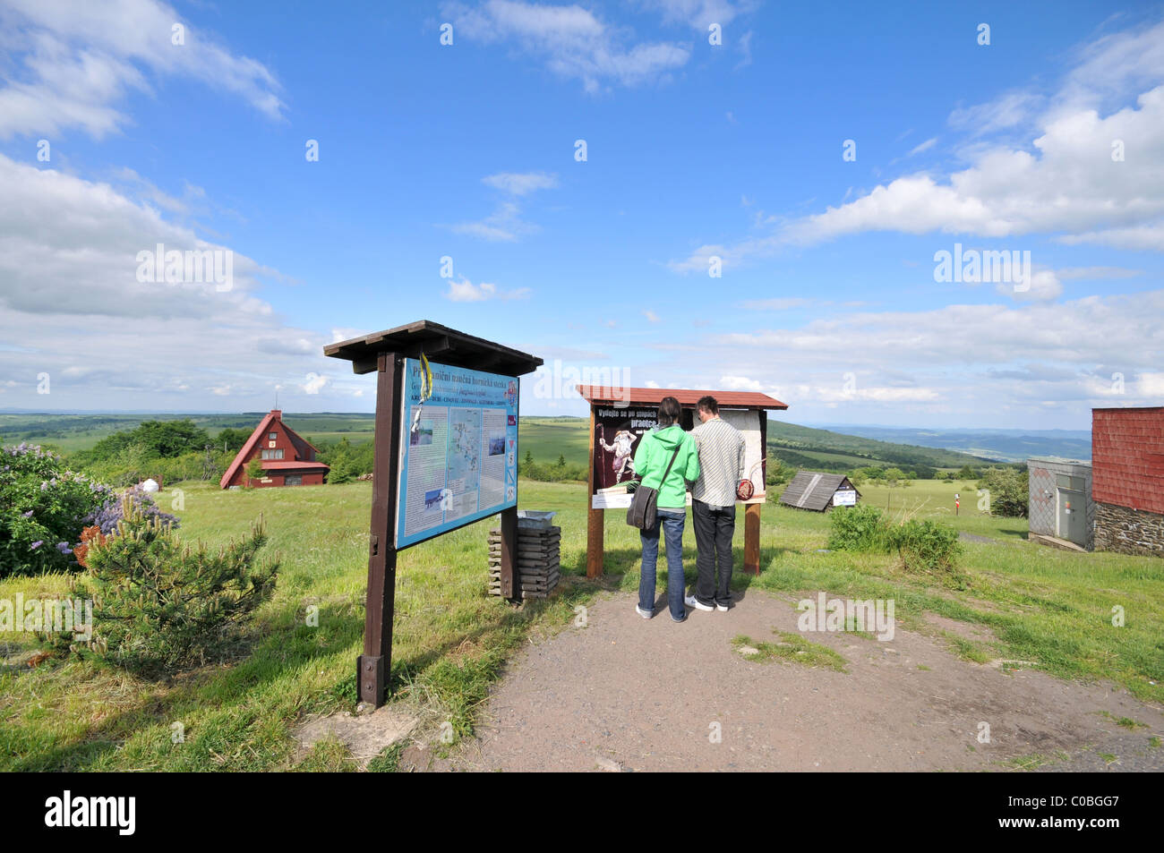 Hikers viewing the information board in a beautiful countryside in ...