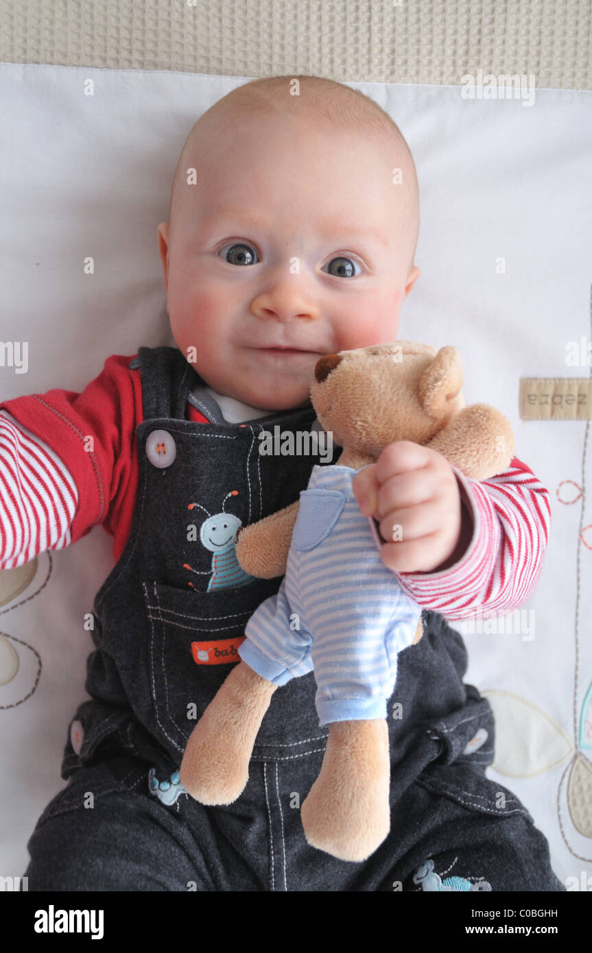 Baby holding a teddy bear Stock Photo - Alamy