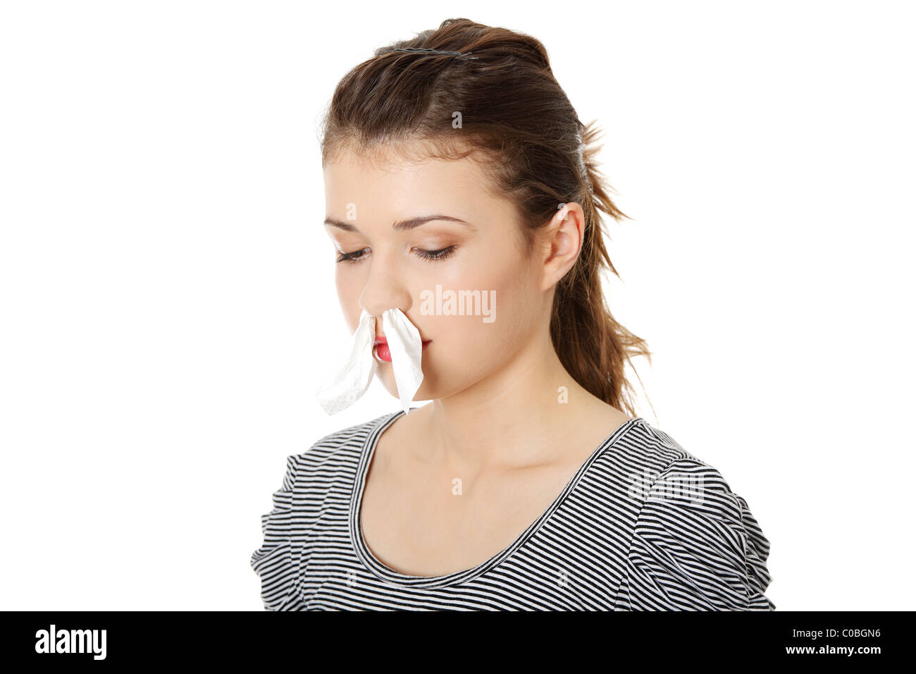 Teen woman with tissue in her nose, isolated on white background Stock ...