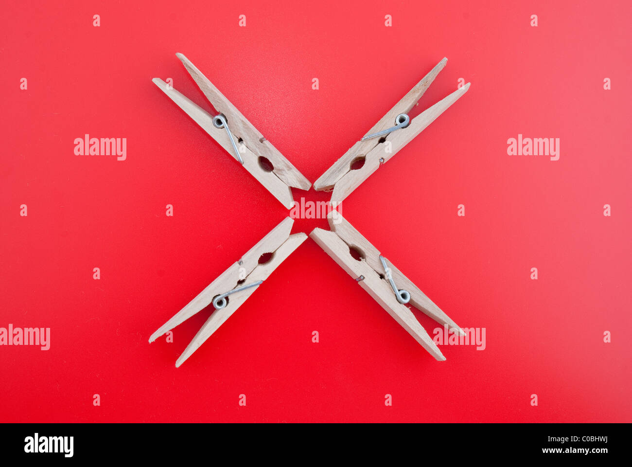 Cross made of wooden clothes pegs on a green background Stock Photo - Alamy