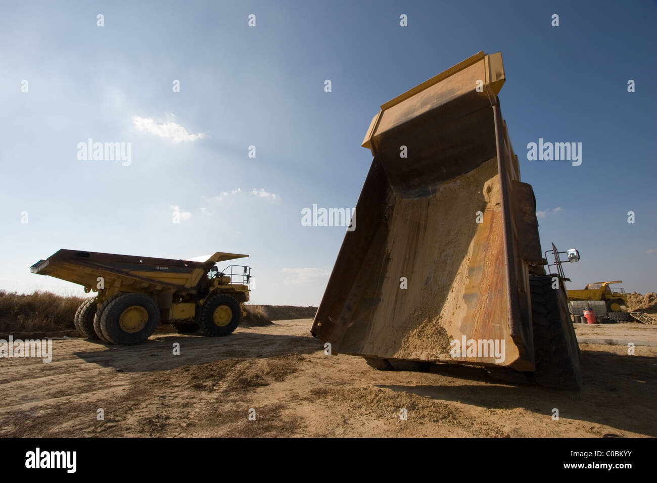 Big mining trucks at work-site, back view Stock Photo - Alamy