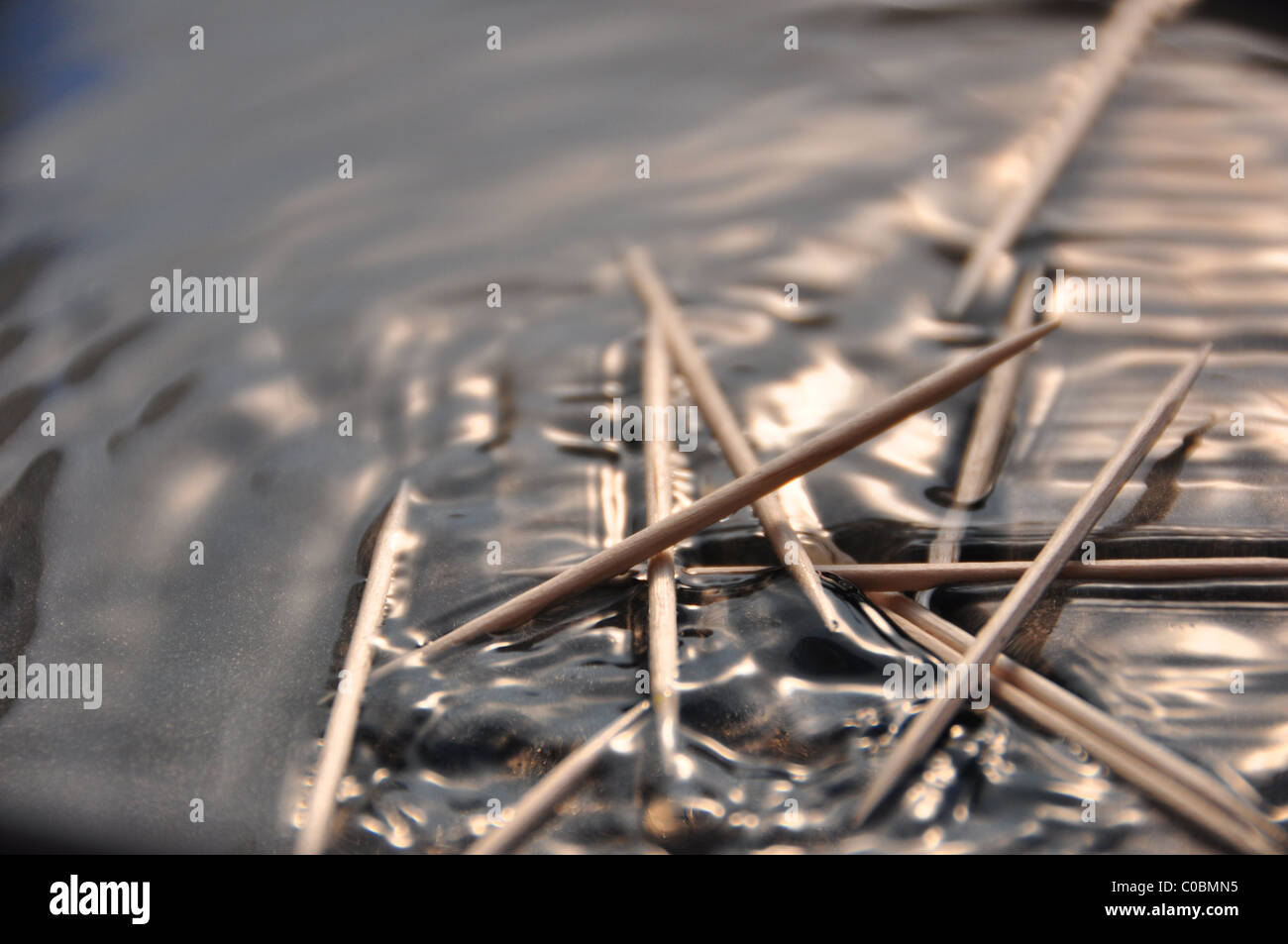 Toothpicks falling into water, macro photo Stock Photo - Alamy