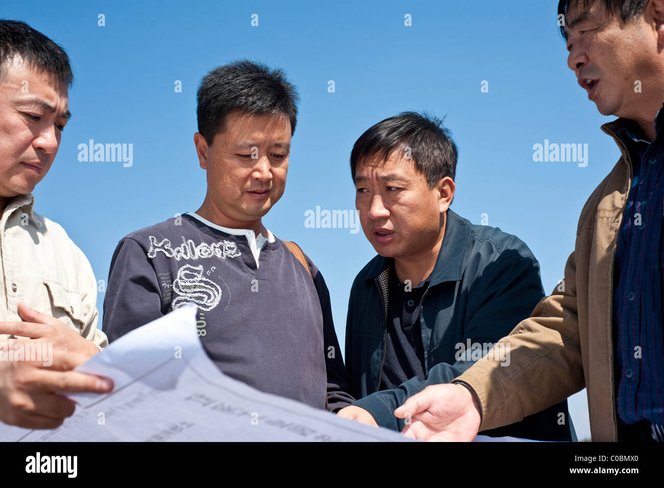 Chinese discussing a blueprint Stock Photo - Alamy