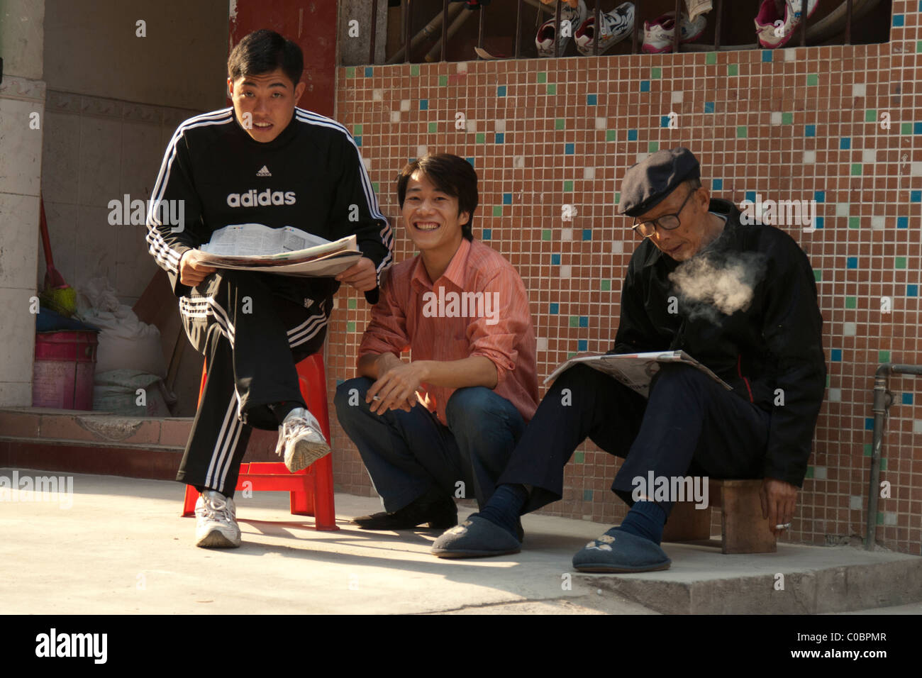Three Chinese men relaxing with newspapers Stock Photo - Alamy