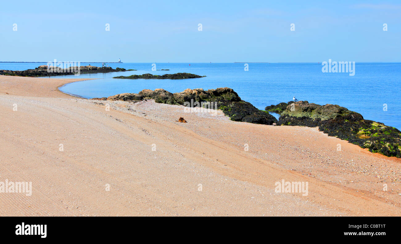 Beautiful empty beach with sand and rocks along shoreline Stock Photo ...