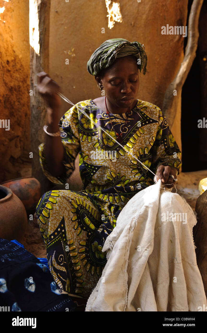 Dogon woman stitching traditional Dogon cloth together, before being ...