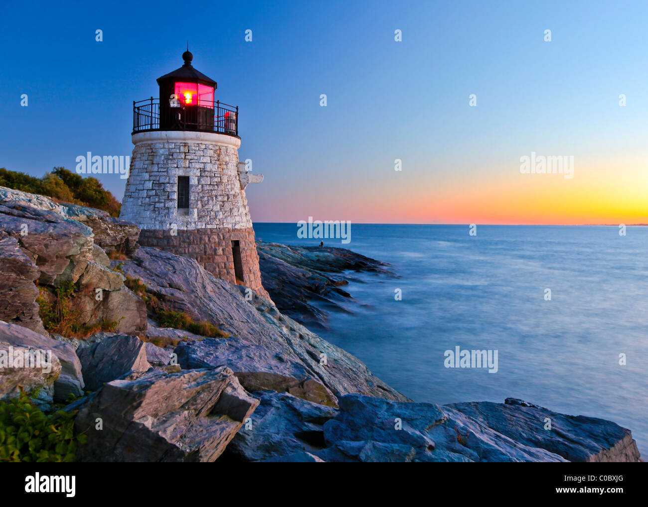 Beautiful lighthouse by the ocean at sunset Stock Photo - Alamy