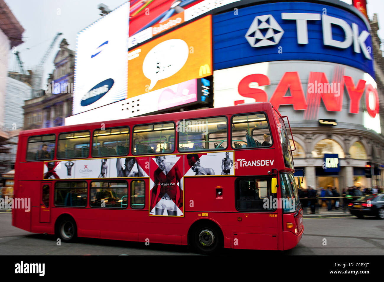 double decker red bus in front of the advertisings of Piccadilly circus ...
