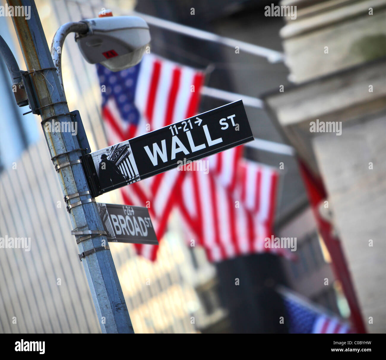 Wall Street sign and flag background in New York City Stock Photo - Alamy