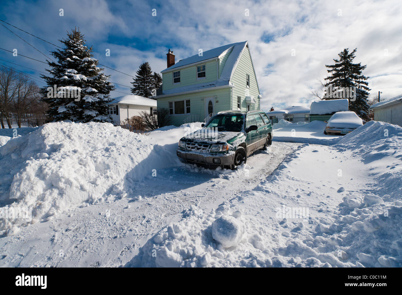 A car sits in a partially shoveled driveway after a snow storm Stock ...