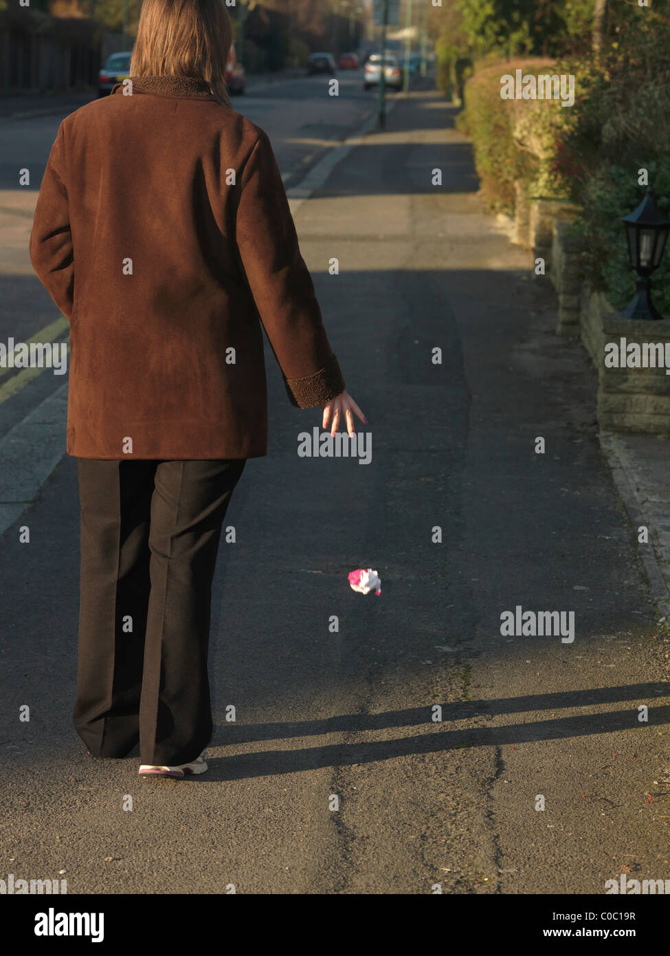 Woman Dropping Litter In The Street England Stock Photo - Alamy