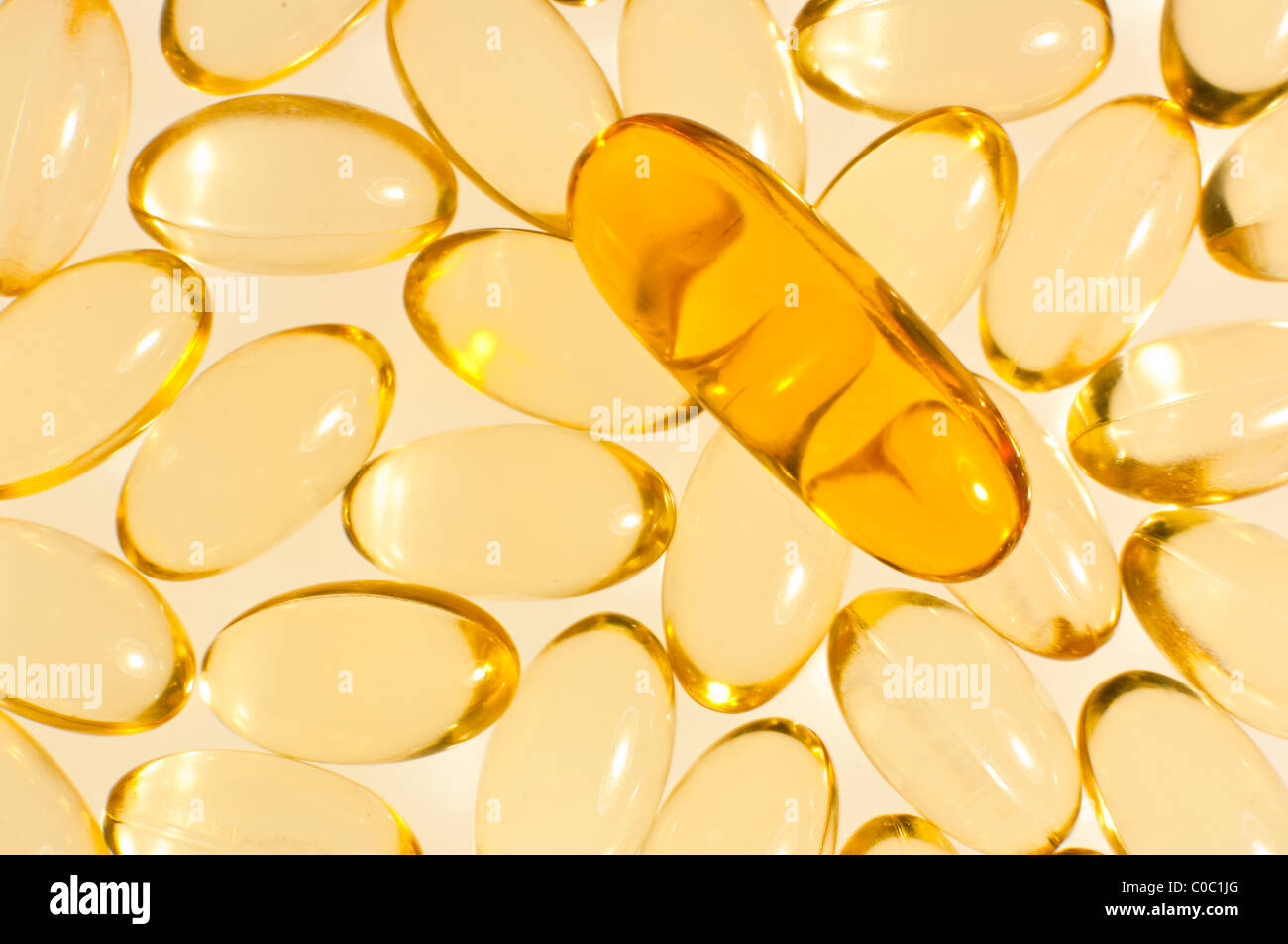 Omega three capsule with smaller Vitamin E capsules Stock Photo - Alamy