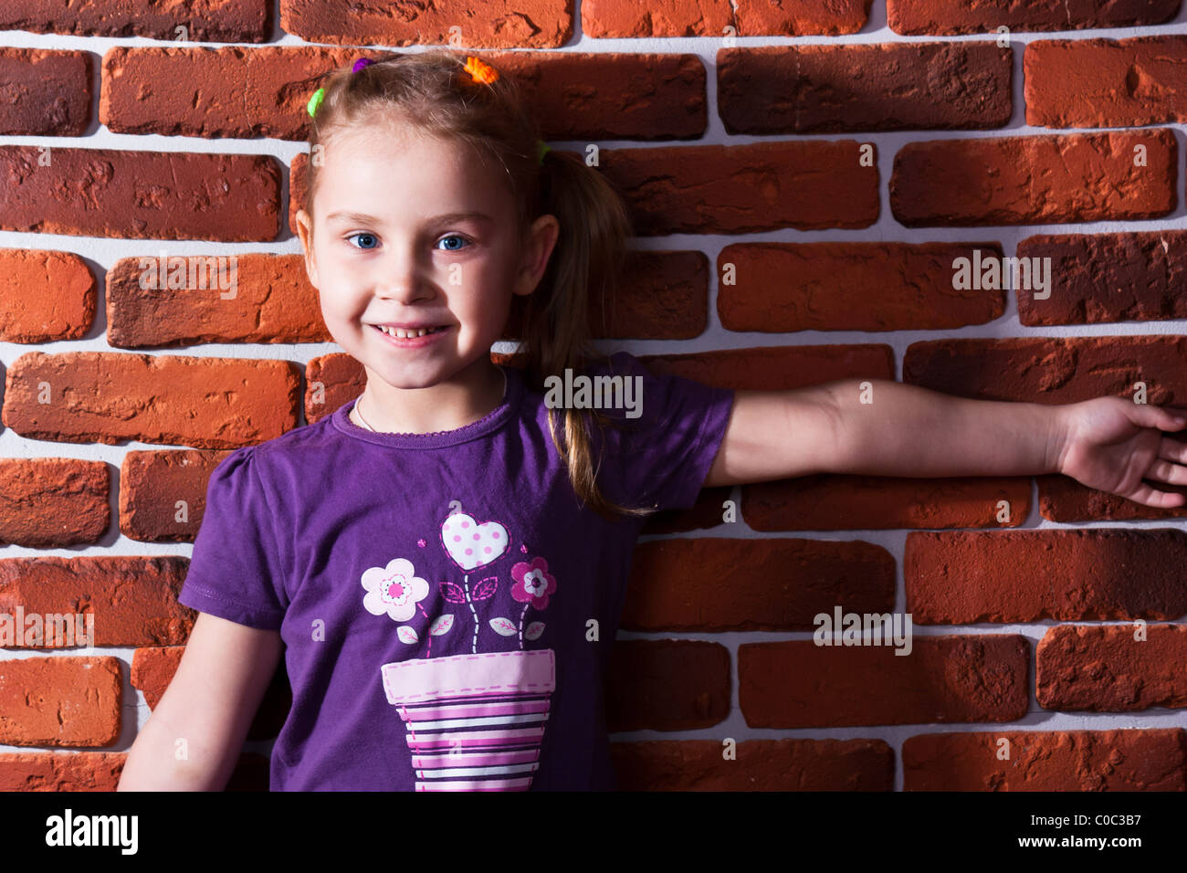 Beautiful smiling girl leaning against the break wall Stock Photo - Alamy