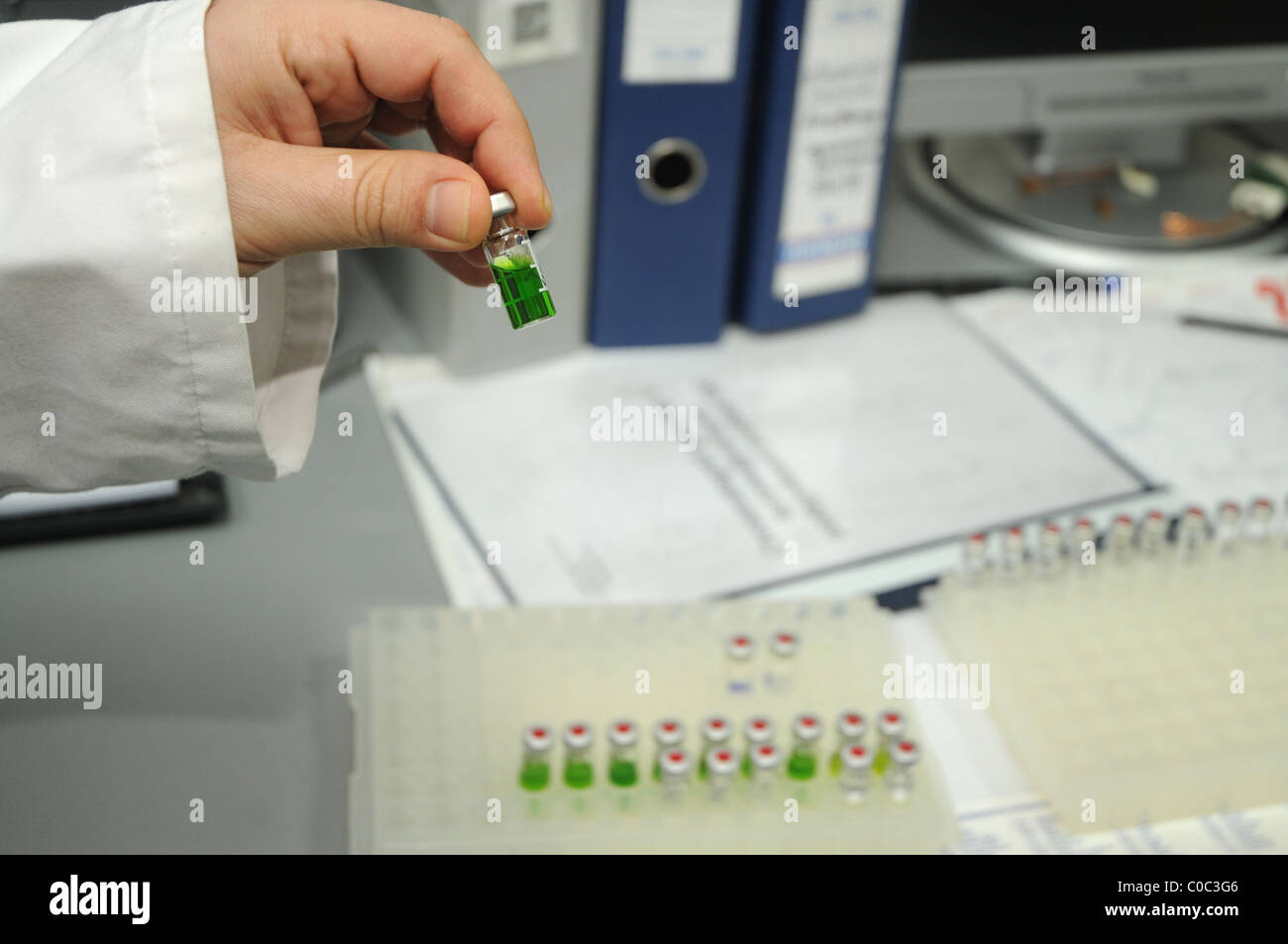 lab assistant showing a small sample vial with marijuana solution in ...